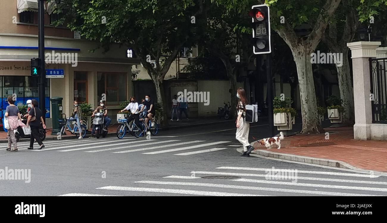 SHANGHAI, CHINA - MAY 29, 2022 - Citizens wear masks as they walk on a ...