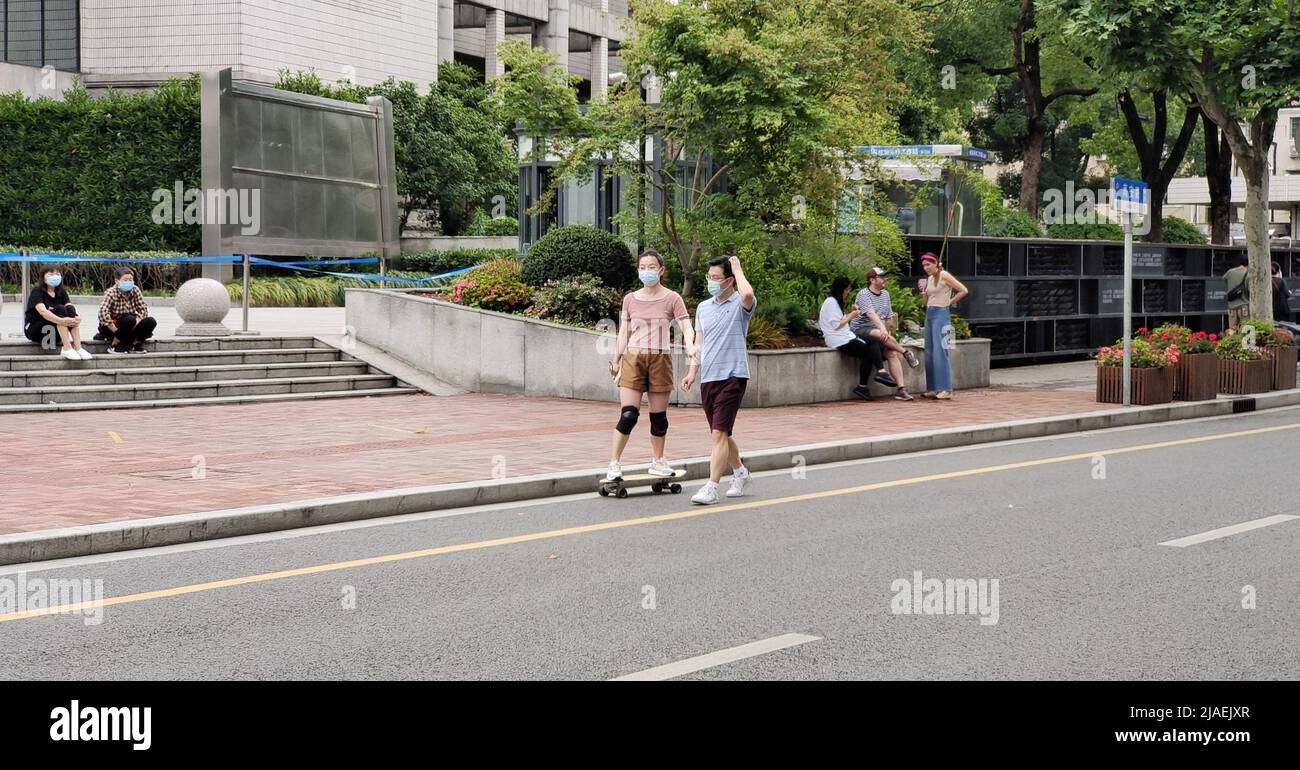 SHANGHAI, CHINA - MAY 29, 2022 - Citizens wear masks as they walk on a ...
