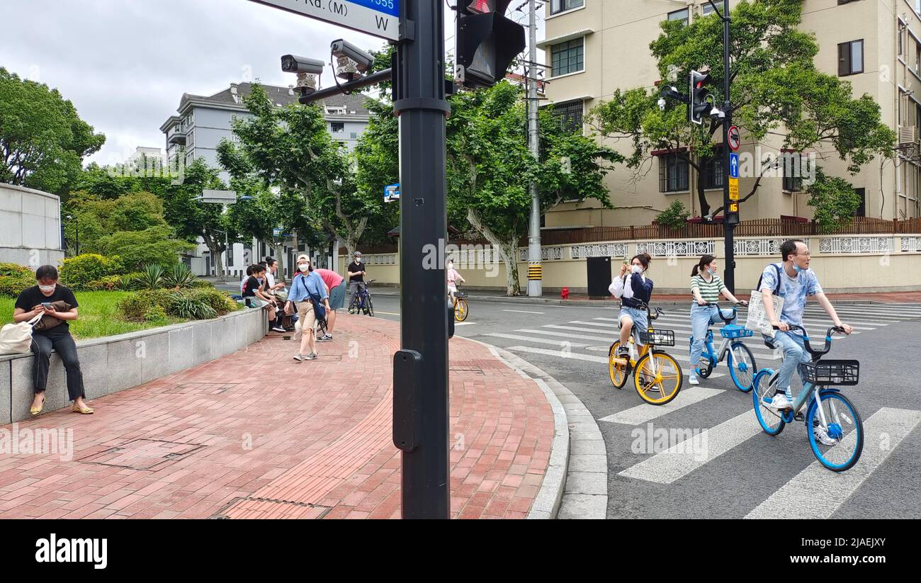 SHANGHAI, CHINA - MAY 29, 2022 - Citizens wear masks as they walk on a ...