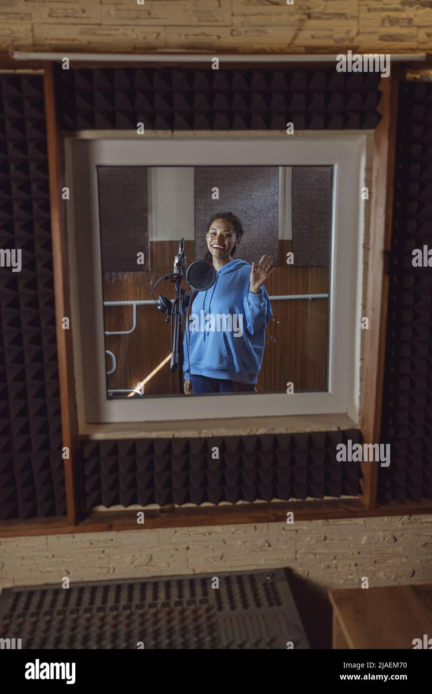 Smiling African American young woman singer standing near microphone ...