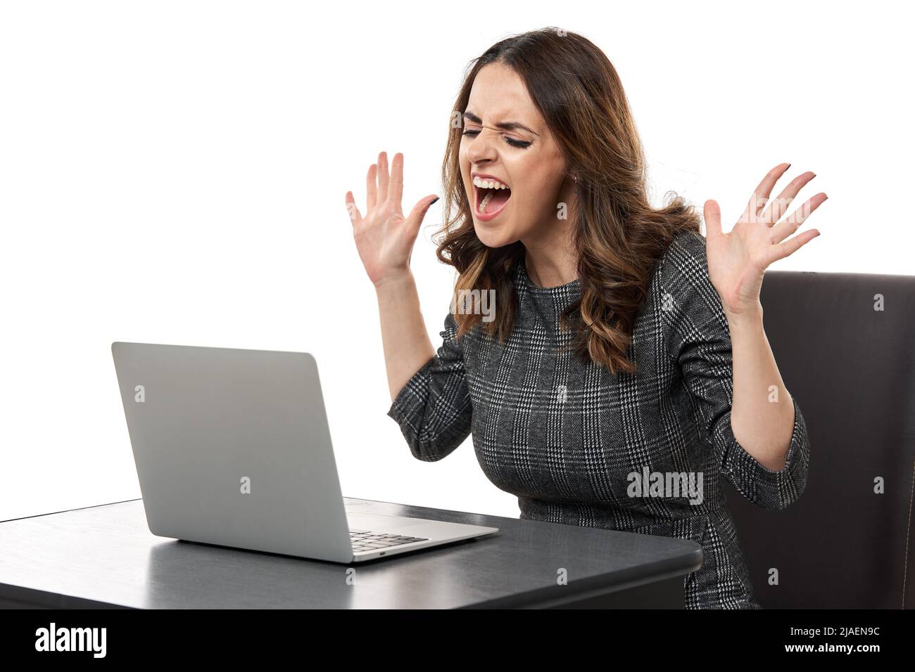 Frustrated and extremely angry businesswoman at her laptop, isolated on ...