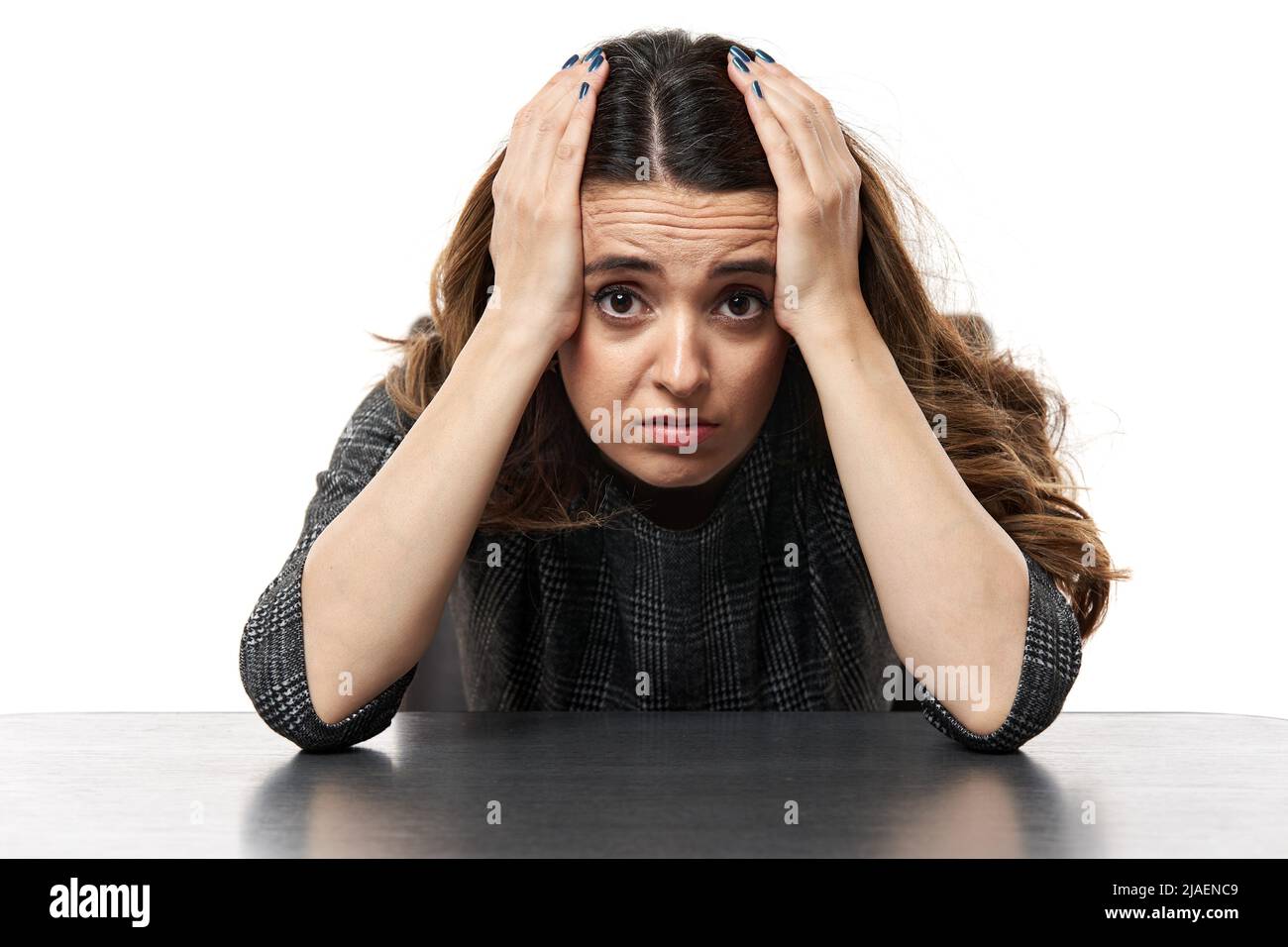 Worried businesswoman with a concerned expression sitting at her desk ...