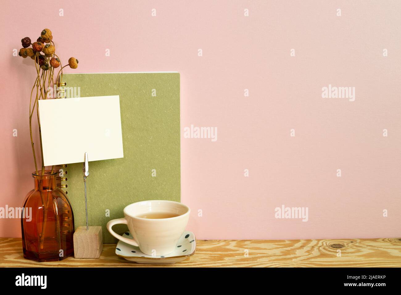 Memo holder and notebook, cup of tea, dry flowers on wooden desk. pink ...