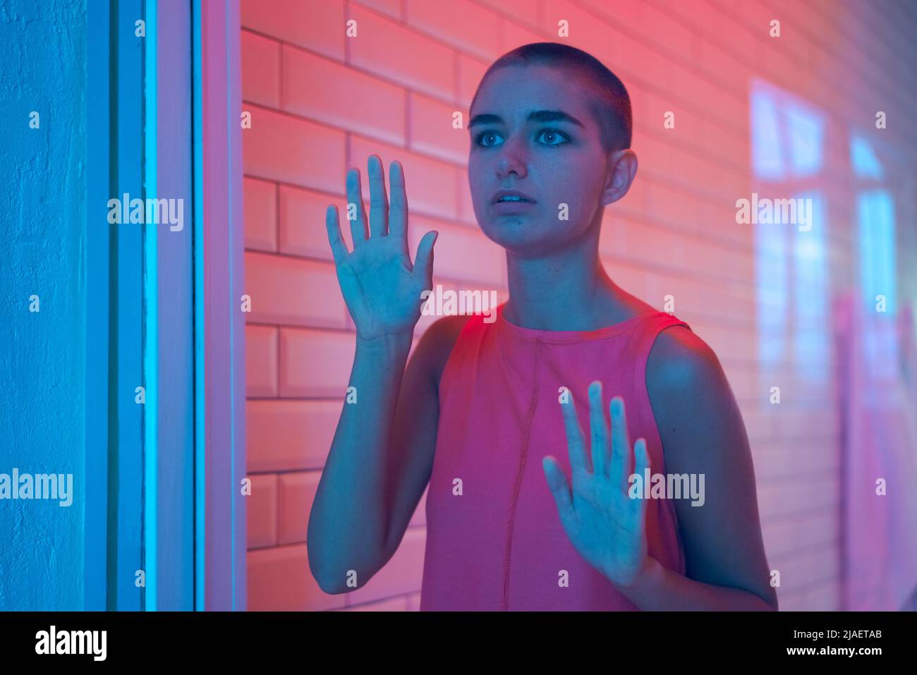 Lonely sad teenager girl student knocking on window in frustration, sad ...