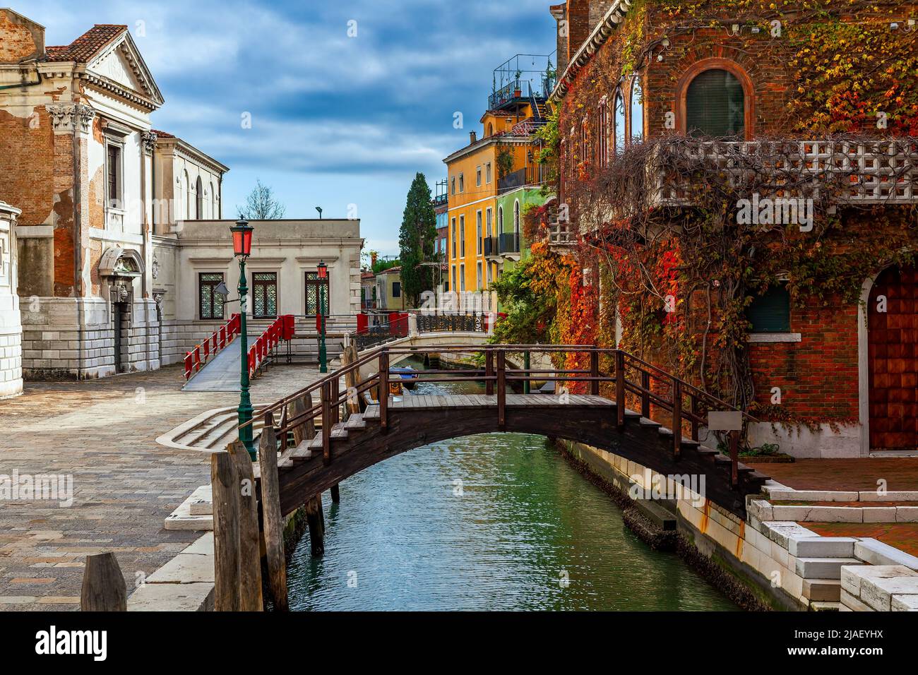 Small wooden bridge over narrow canal and typical colorful houses in ...