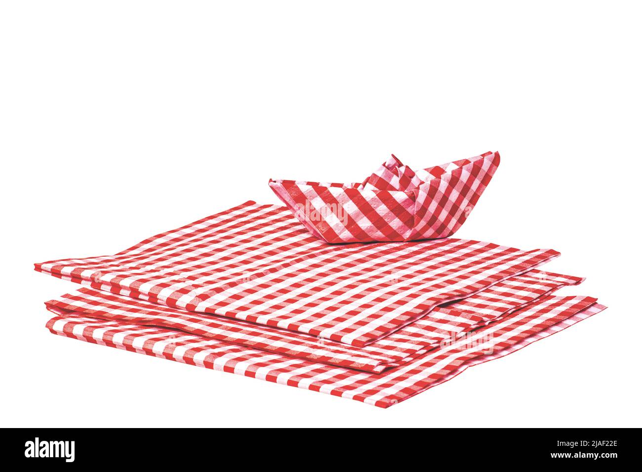 Closeup of a stack of red checked paper napkins and a folded paper ship ...