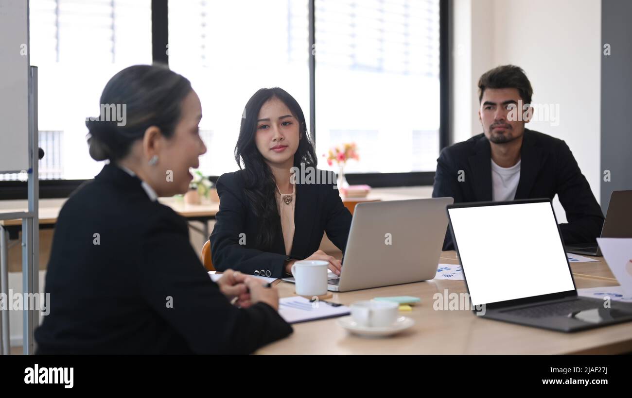 Middle aged female team leader talking, giving instructions to diverse ...