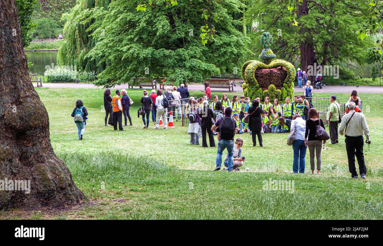 People pose in front of topiary crown hi-res stock photography and ...