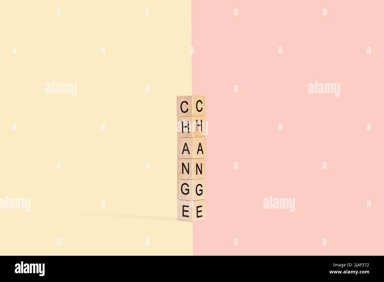 Wooden cubes with the word Change on a pink and yellow background with ...