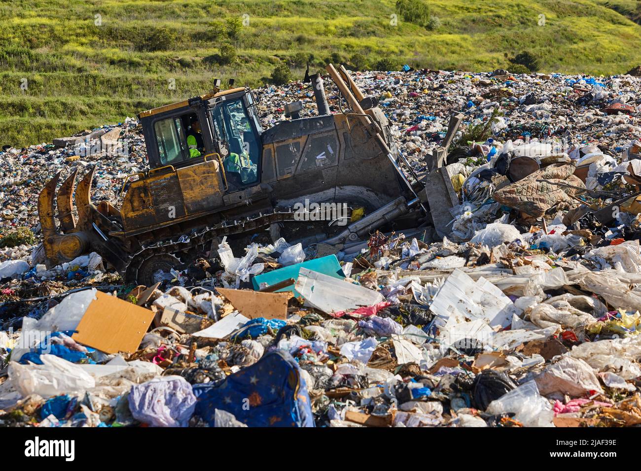 Heavy machinery shredding garbage in an open air landfill. Waste Stock ...