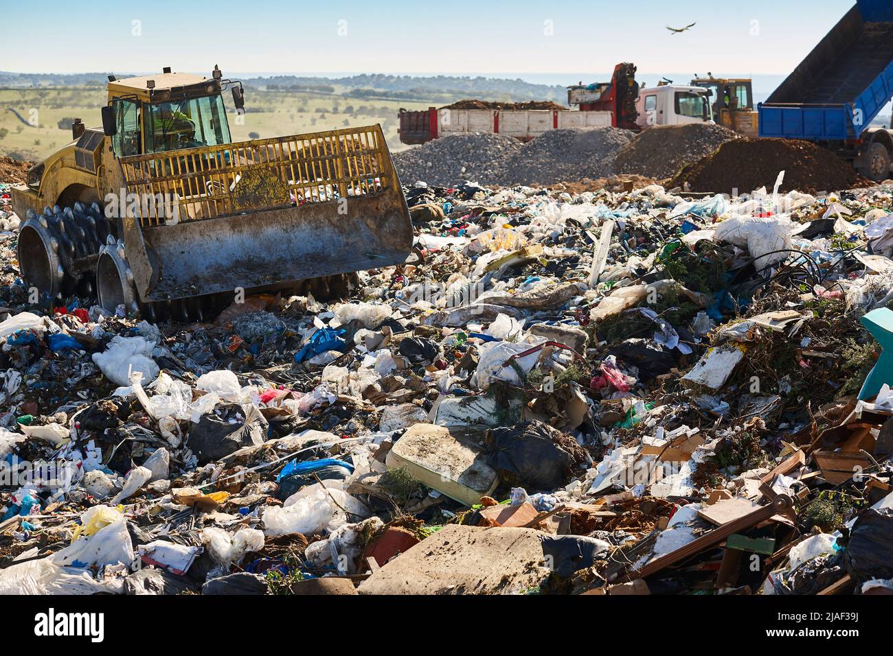 Heavy machinery shredding garbage in an open air landfill. Waste Stock ...