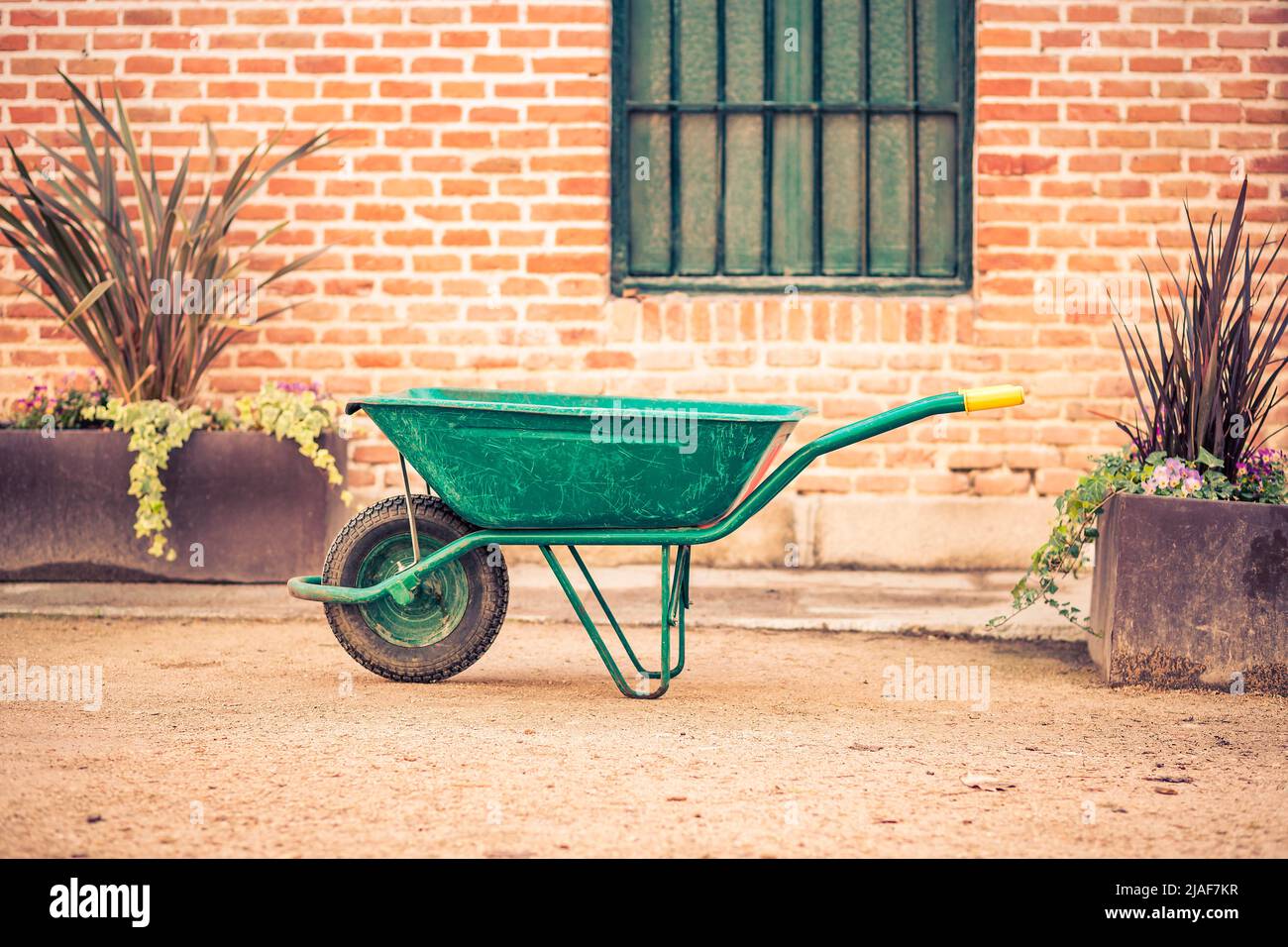 empty green steel wheelbarrow on the ground Stock Photo - Alamy