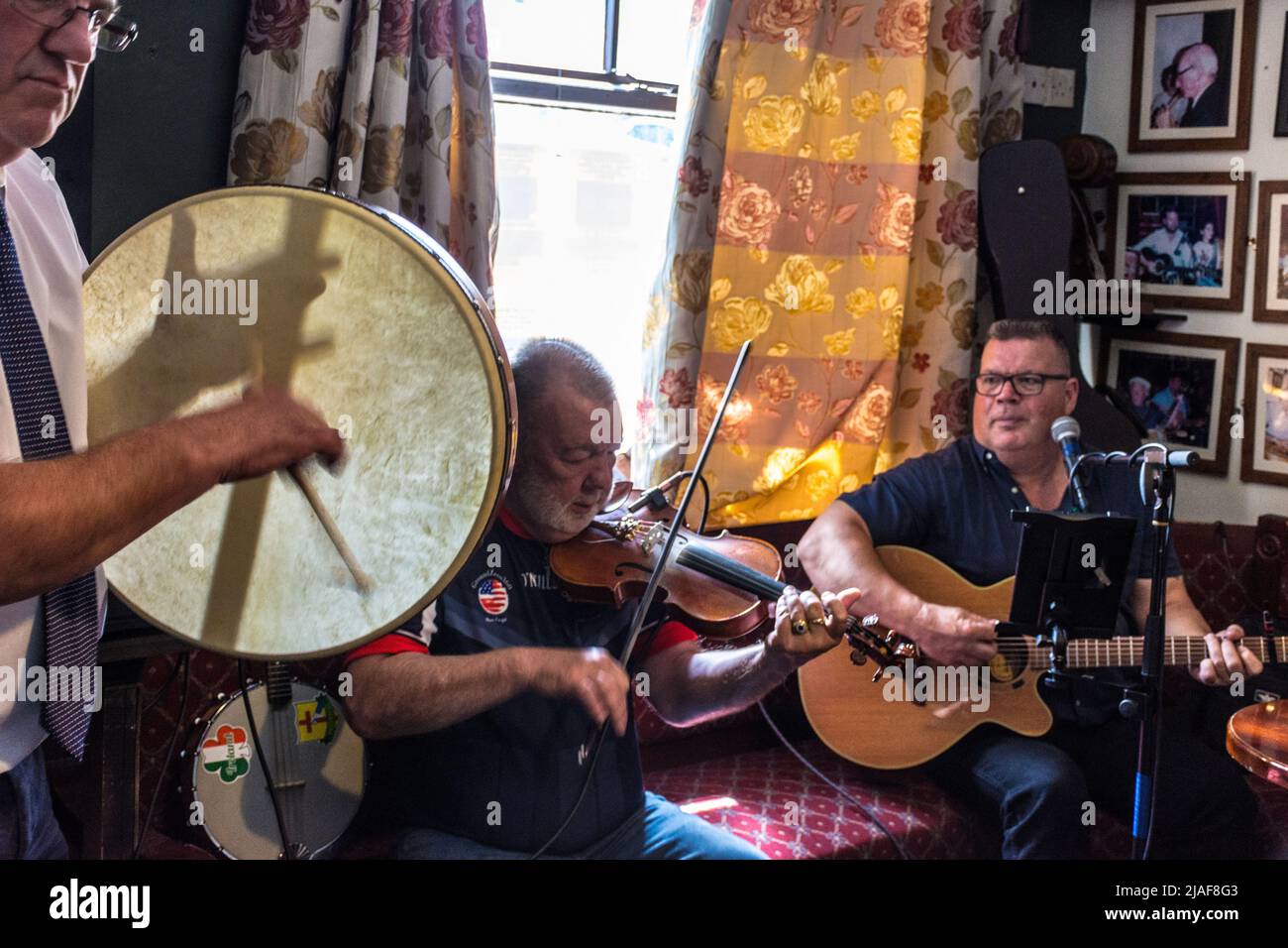 Traditional Irish music in a Donegal bar. A man plays percussion on a ...