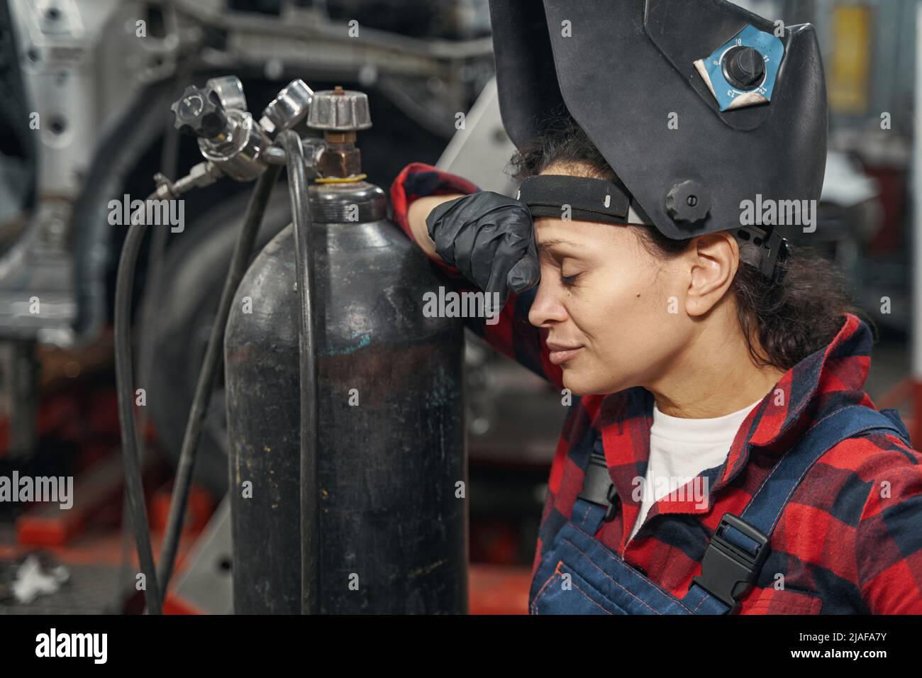 Woman auto mechanic standing near gas cylinder in garage Stock Photo ...