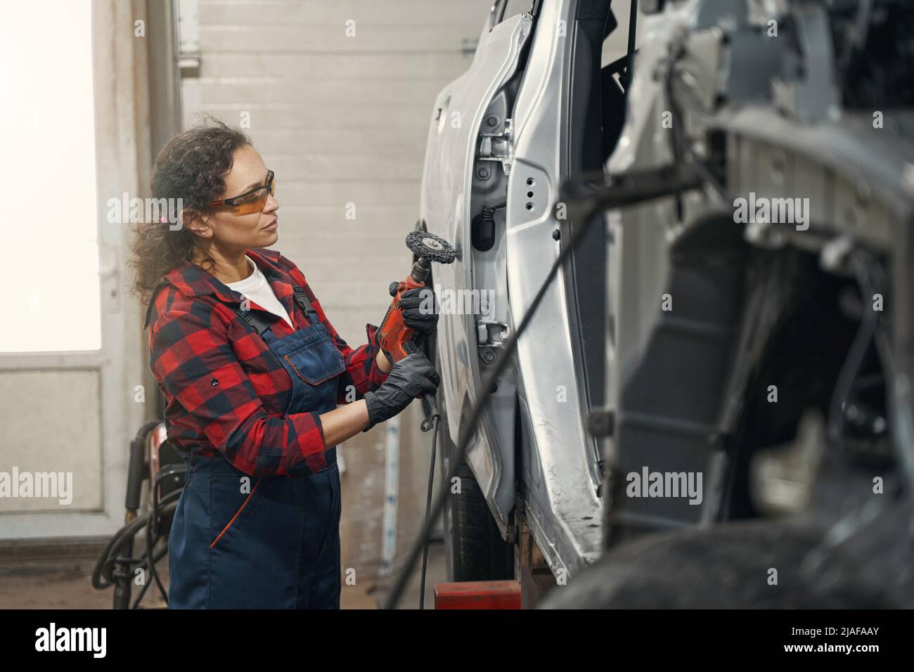 Female auto mechanic repairing car in auto service garage Stock Photo ...