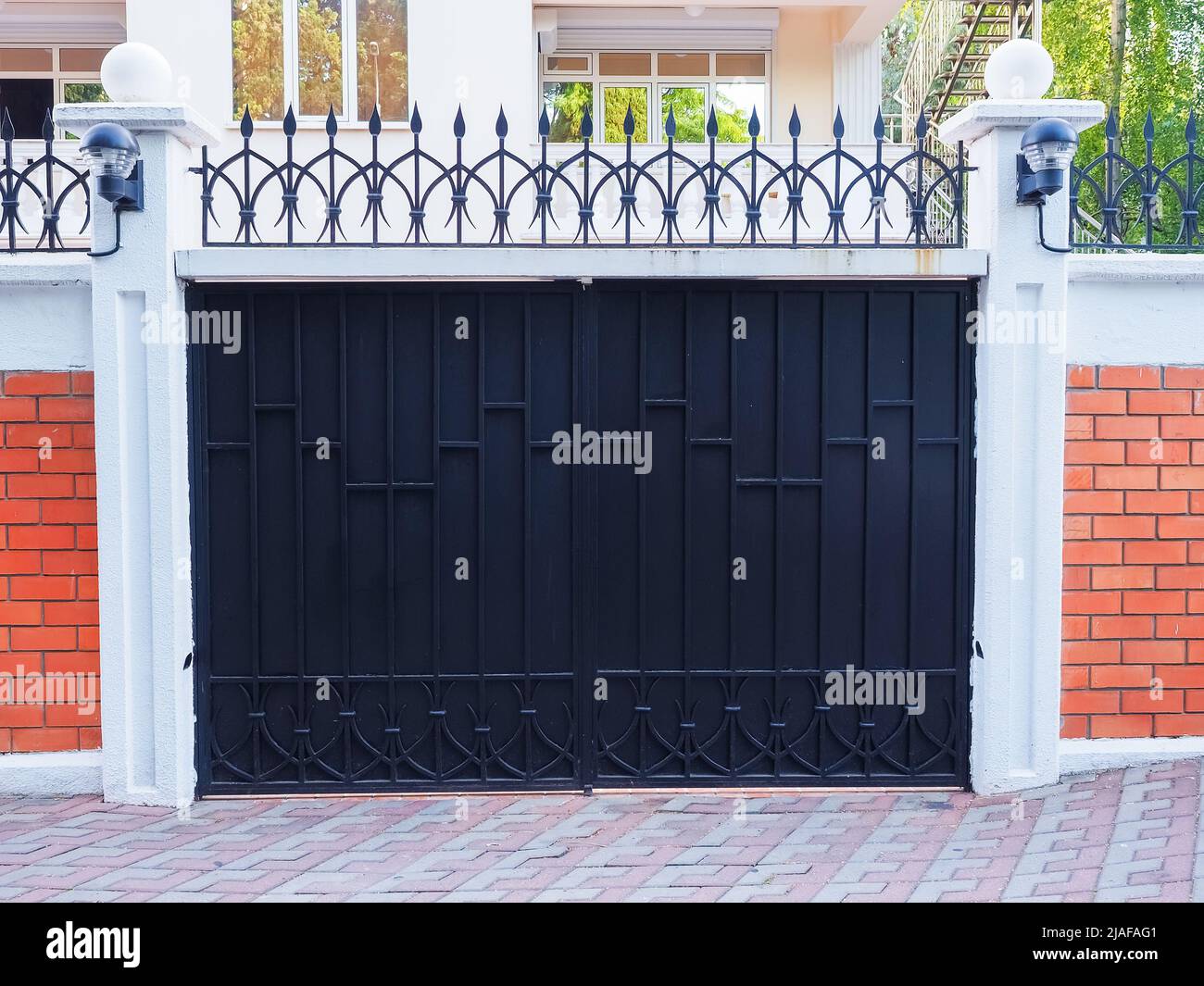Iron black gates with a forged pattern and sharp tips at the top ...