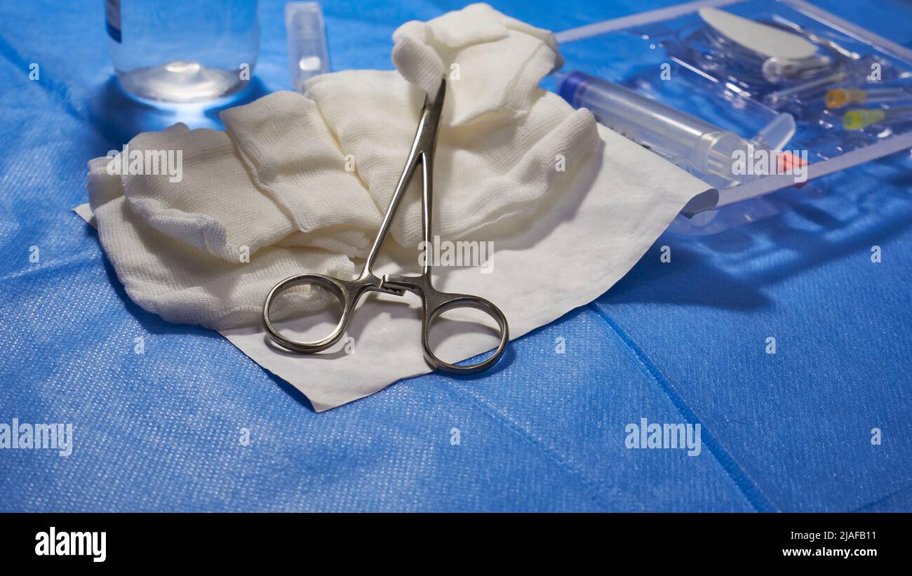 Metal forceps and sterile gauze swabs on a medical table close-up Stock ...