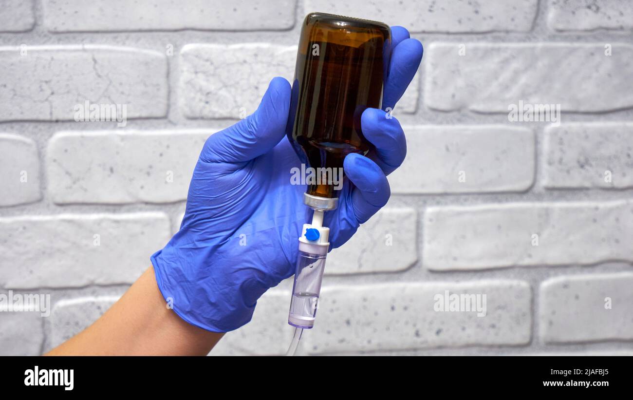 Medical dropper and doctor's hand in a glove Stock Photo - Alamy