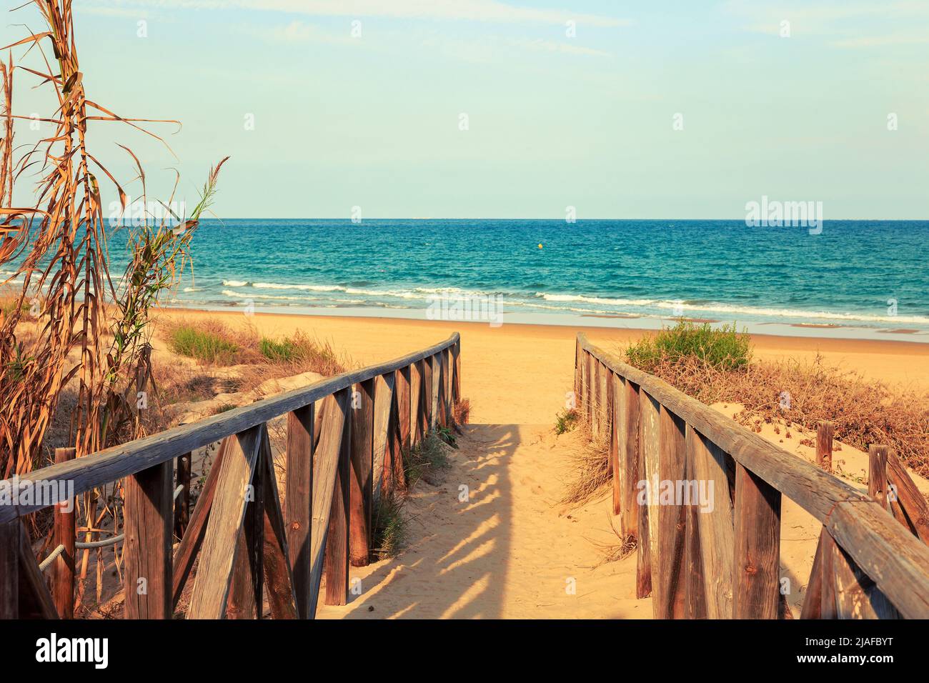 tranquil scene with wooden bridge heading out to sea Stock Photo - Alamy