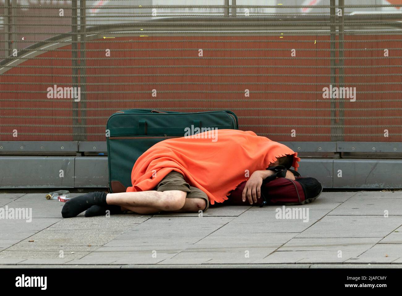 homeless man sleeping on the floor on a train station platform, Germany ...