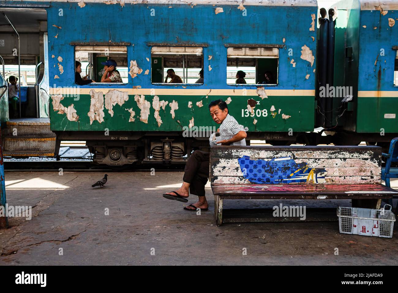 Yangon, Myanmar. 13th Jan, 2020. A man sits on a bench at the Yangon Central Railway Station ...