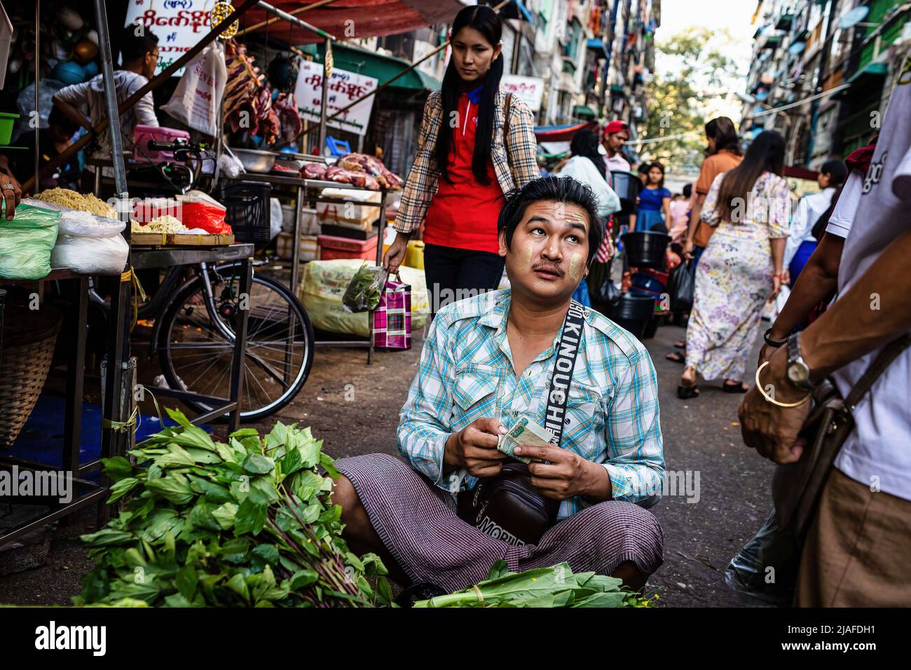 Yangon, Myanmar. 16th Jan, 2020. A street seller looks at a customer ...