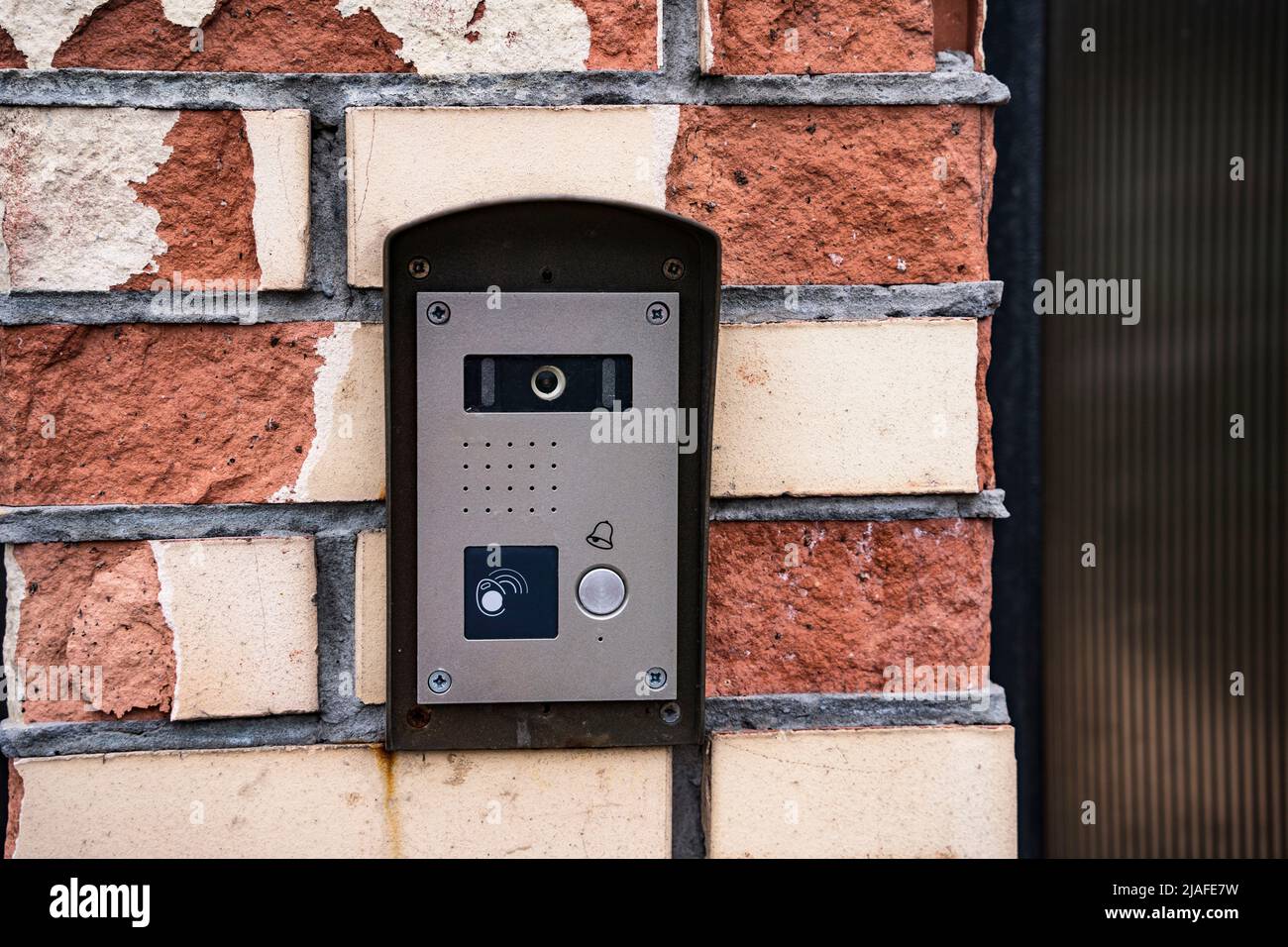 intercom panel with a video camera on the brick fence of private house ...