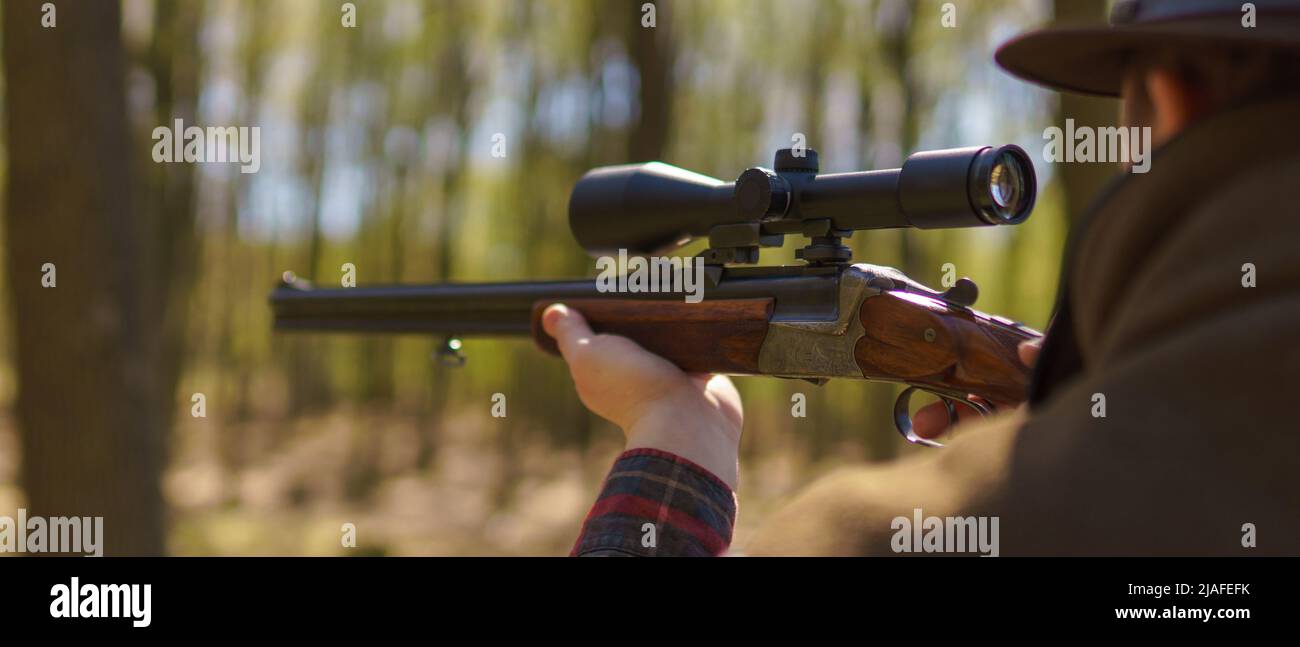 Hunter man aiming with rifle gun on prey in forest Stock Photo - Alamy
