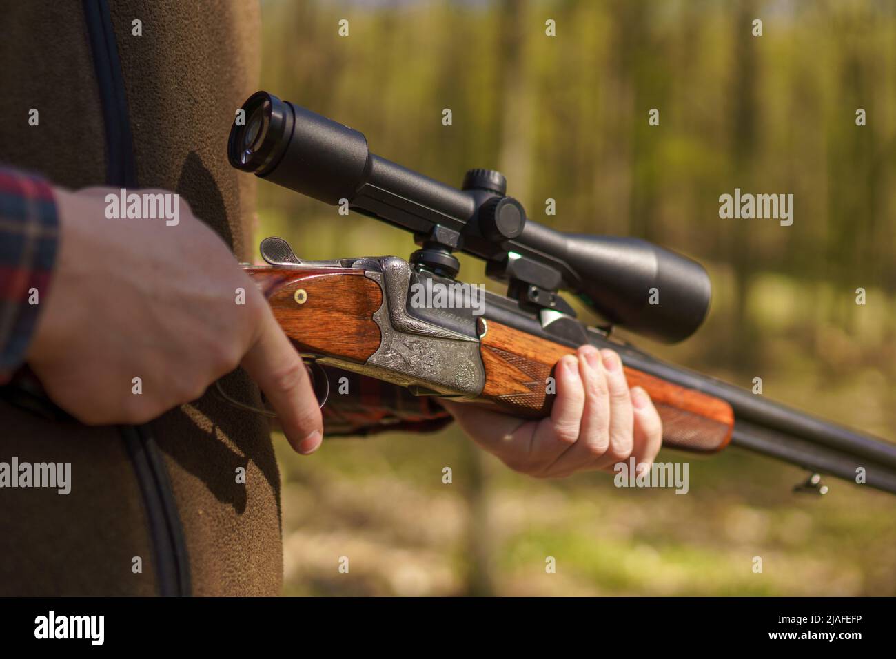 Close-up of hunter man waiting with rifle gun on prey in forest Stock ...