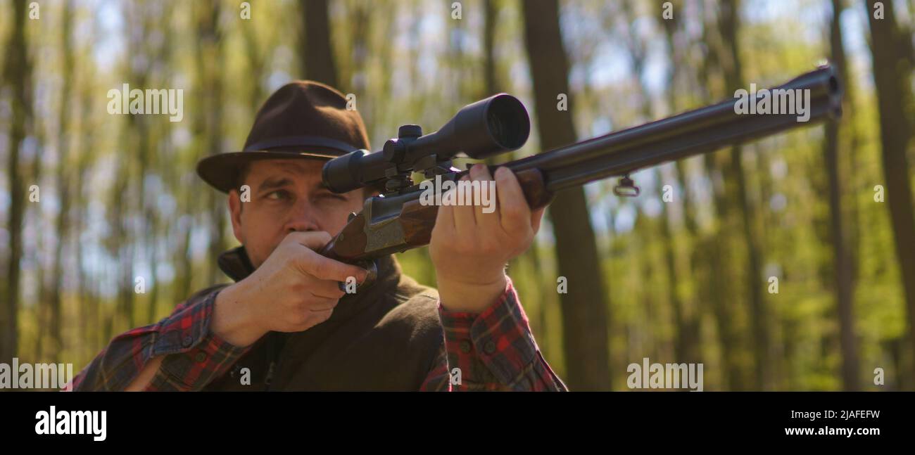 Hunter man aiming with rifle gun on prey in forest Stock Photo - Alamy