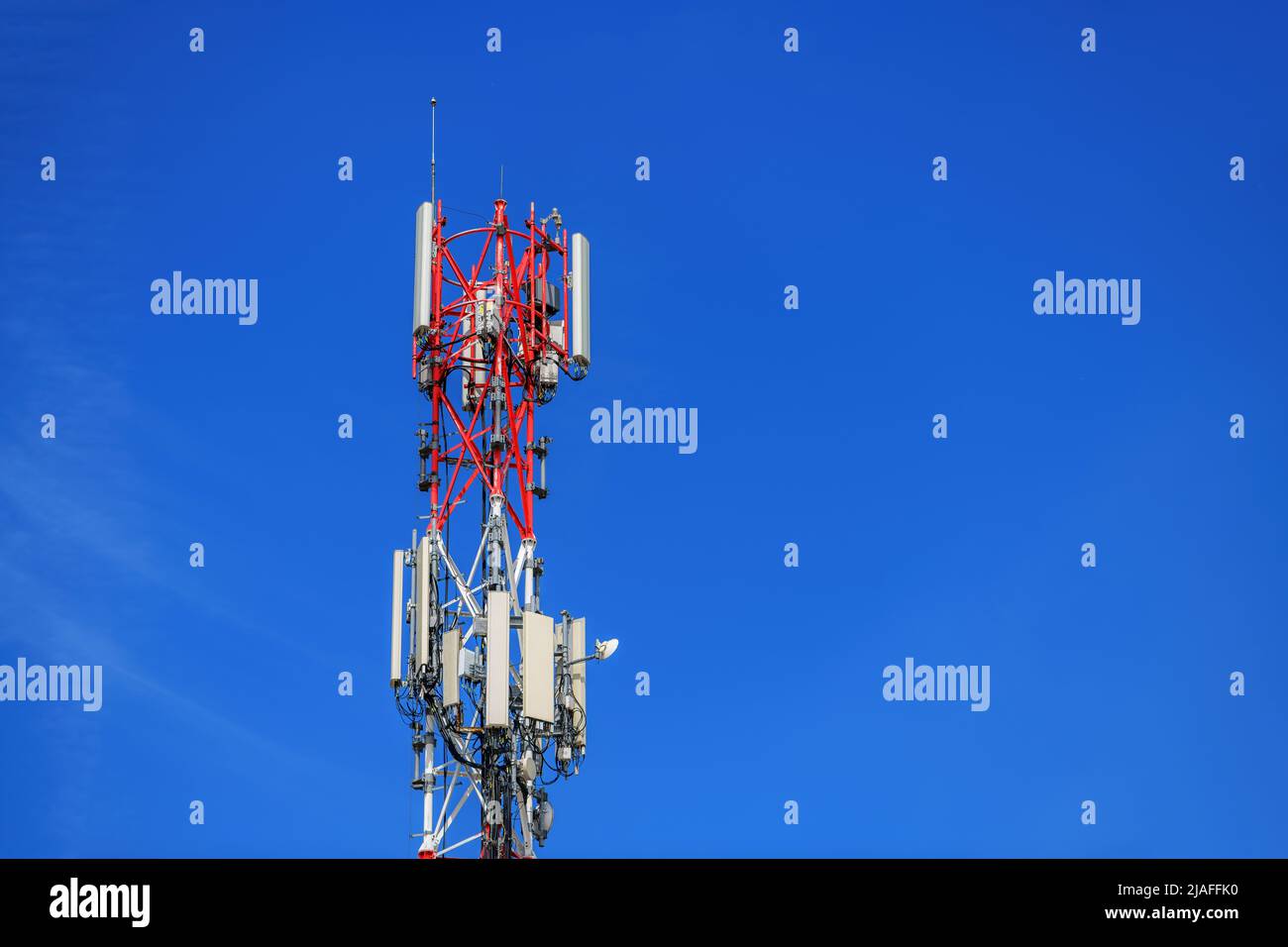 Telecommunication pylon with signal repeaters and antennas against blue sky for wireless ...