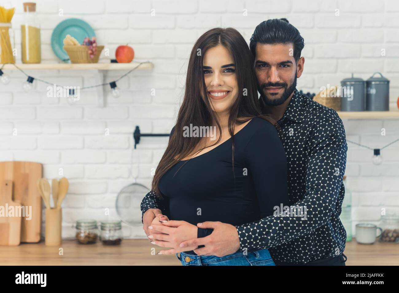 An attractive Latin couple embracing and looking at the camera in the ...