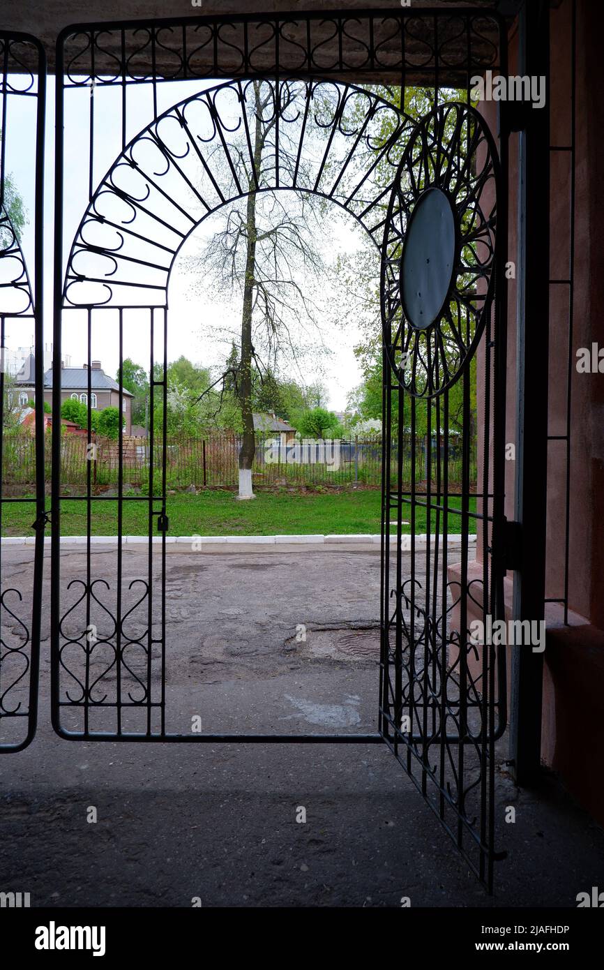 Metal gate with an open wicket in the arch Stock Photo - Alamy