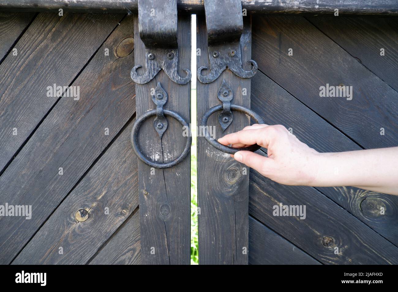 Woman's hand opens the ancient gate Stock Photo - Alamy