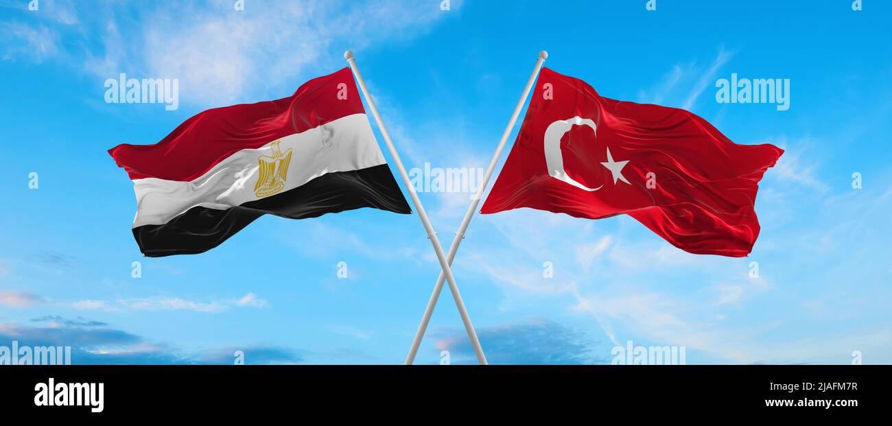 two crossed flags Egypt and Turkey waving in wind at cloudy sky ...