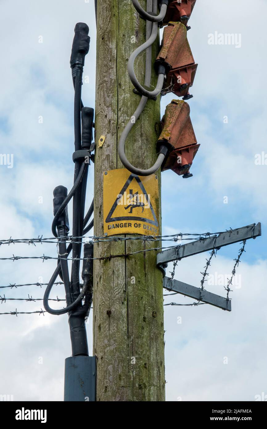 Danger of Death sign on a wooden power pole with various connecters and ...