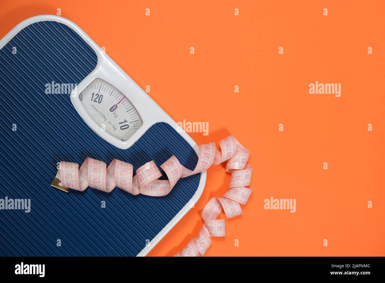 Floor blue scales and centimeter measuring tape on an orange background ...
