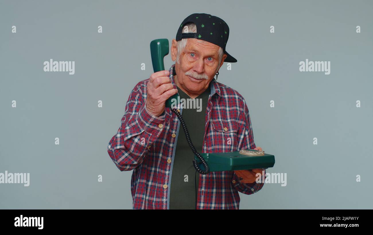 Cheerful tourist man secretary talking on wired vintage telephone of ...