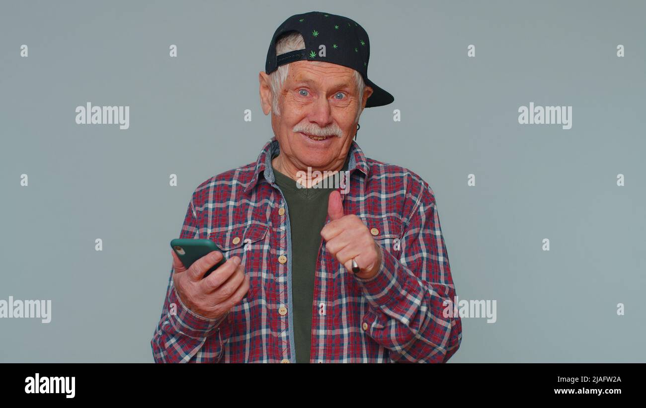 Senior man using mobile phone typing post on web sms message browsing ...