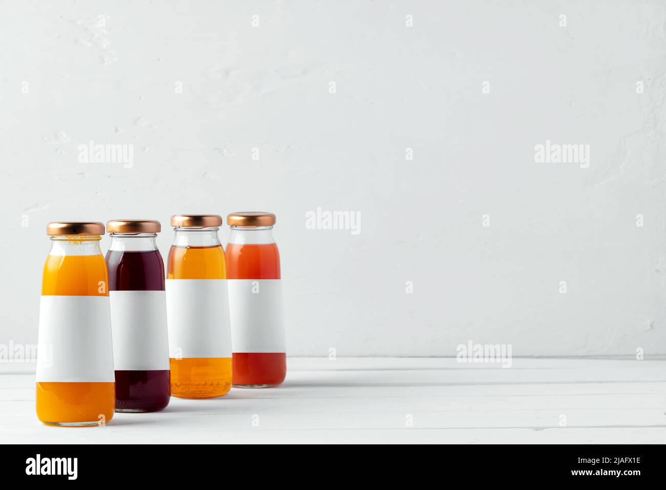 Glass bottles of different juices on white background Stock Photo - Alamy