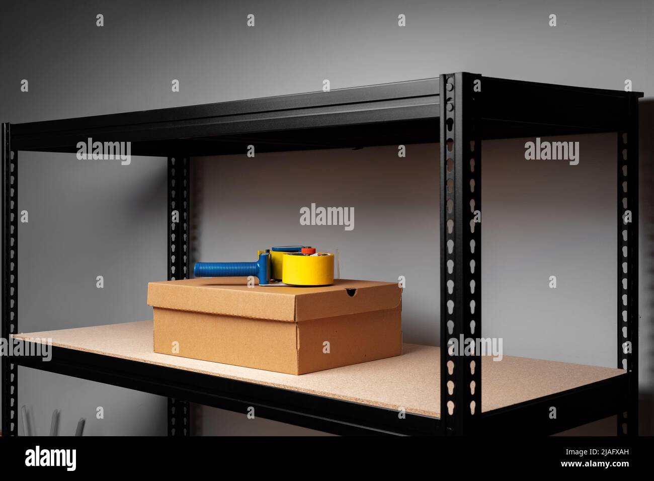 Stand shelf with one packed cardboard box Stock Photo - Alamy