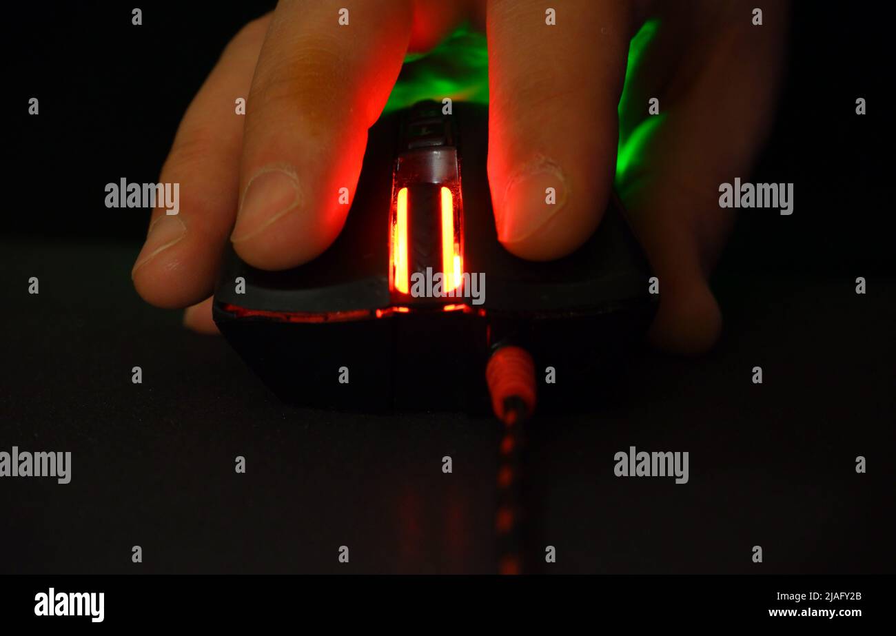 Computer mouse and hand glows in the dark Stock Photo - Alamy