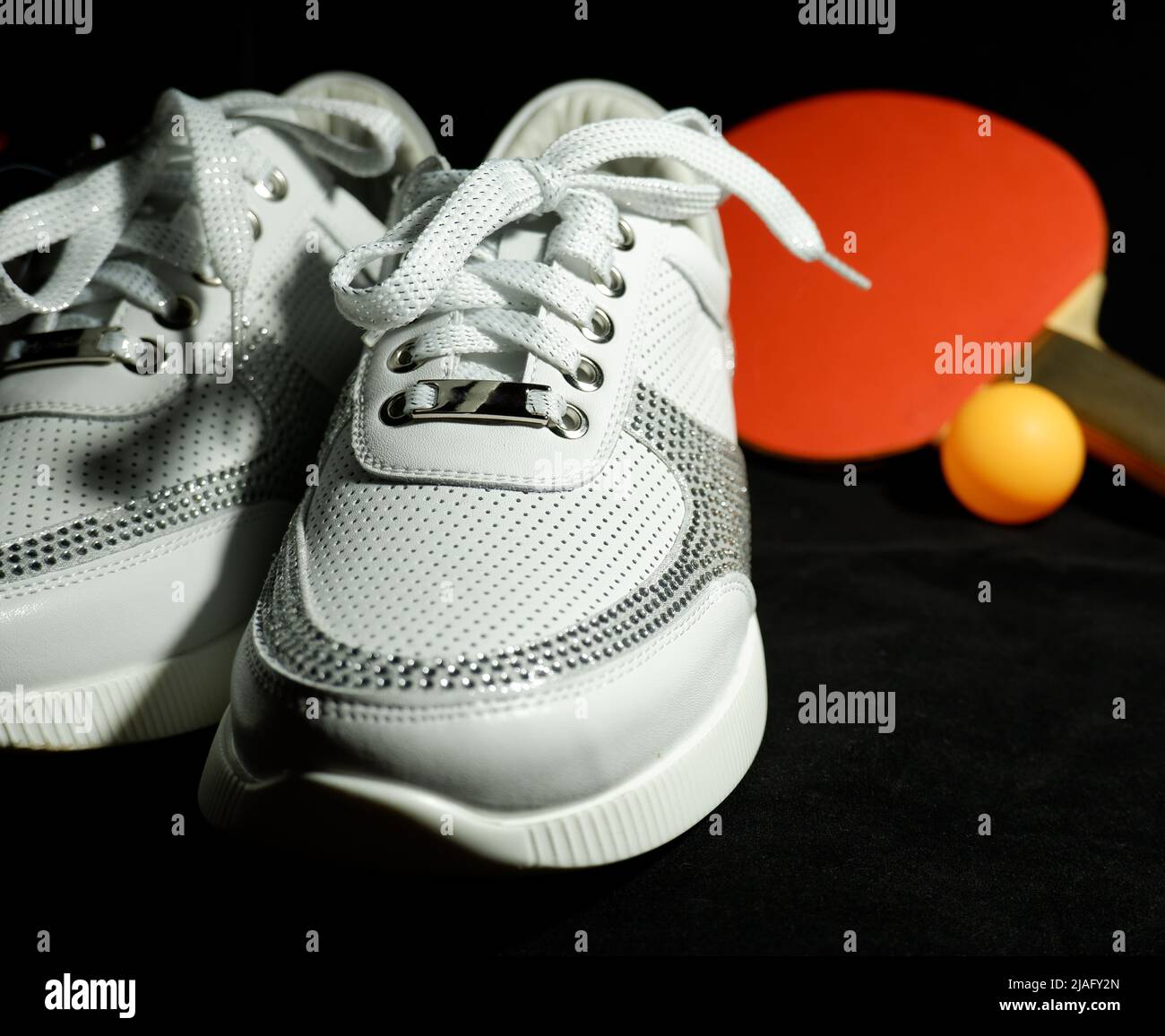 white sports sneakers, racket and ball on black background Stock Photo ...