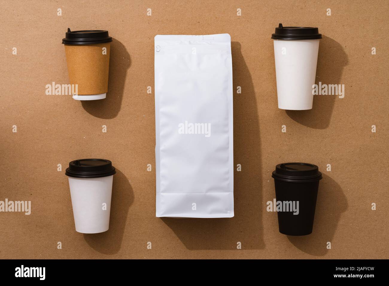 Blank coffee package with copy space and takeout cups on beige ...