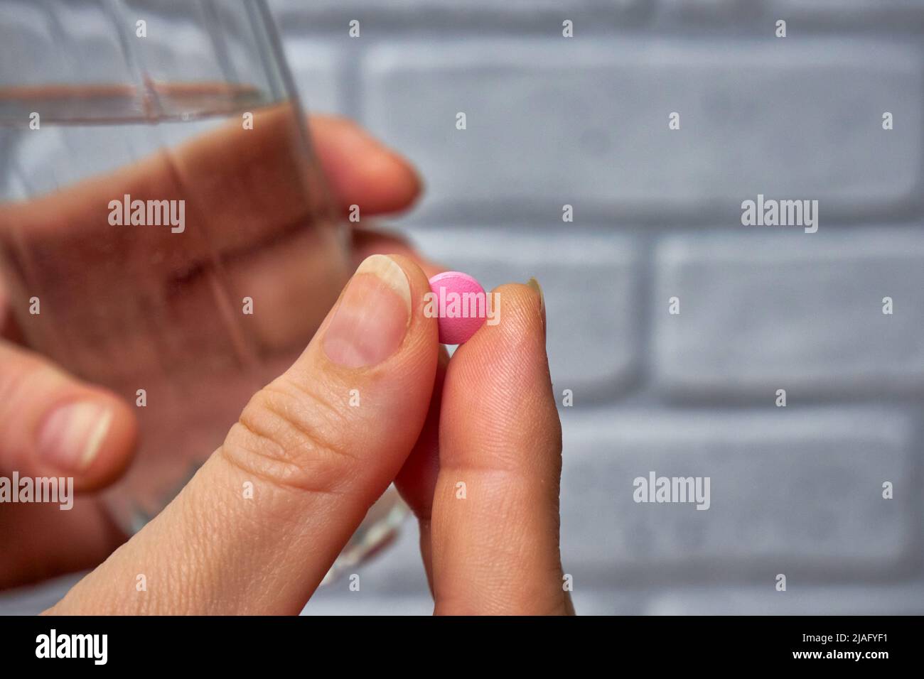 Female hands with pill and glass of water Stock Photo - Alamy
