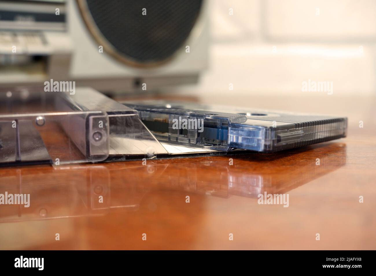 Compact cassette on the background of a stereo tape recorder. Old audio ...