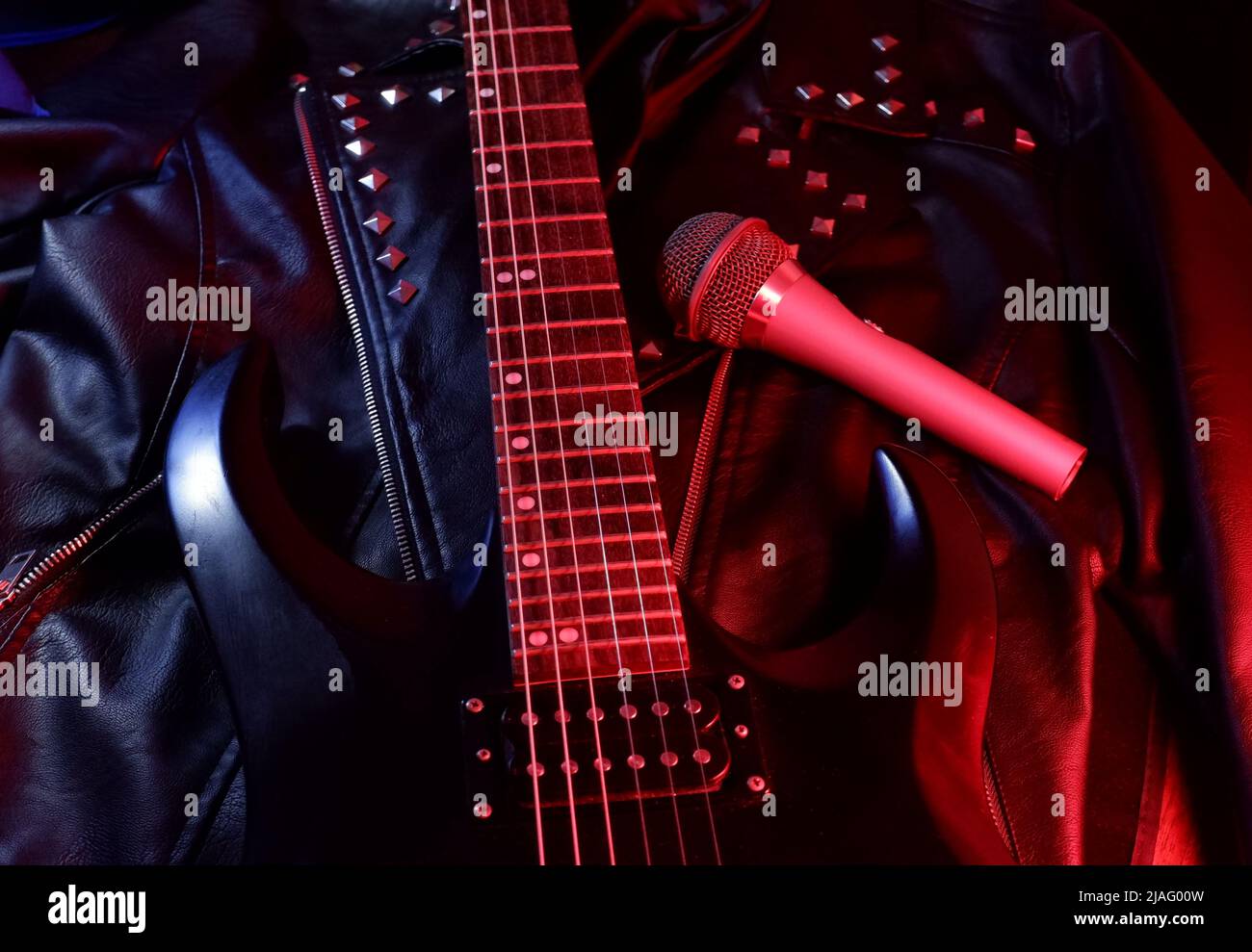 Guitar and microphone on a leather jacket Stock Photo - Alamy