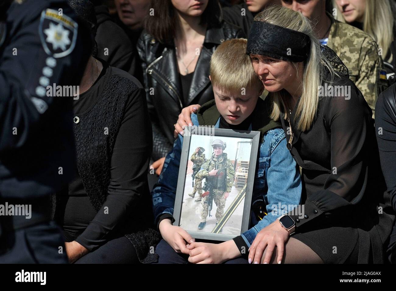 VINNYTSIA, UKRAINE - MAY 29, 2022 - A woman hugs a boy holding a ...