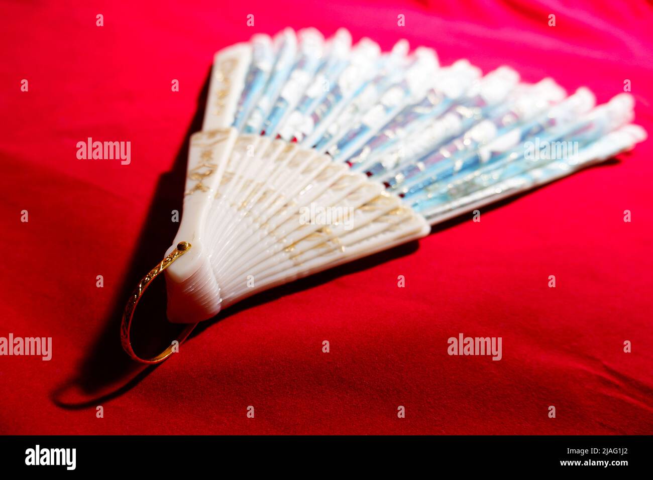 Opened Japanese fan on a red background Stock Photo - Alamy