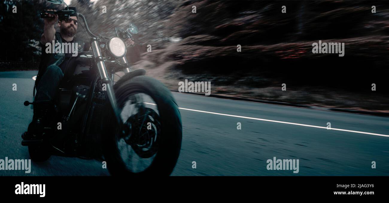 Serious brutal biker riding motorbike in speed highway in summer ...